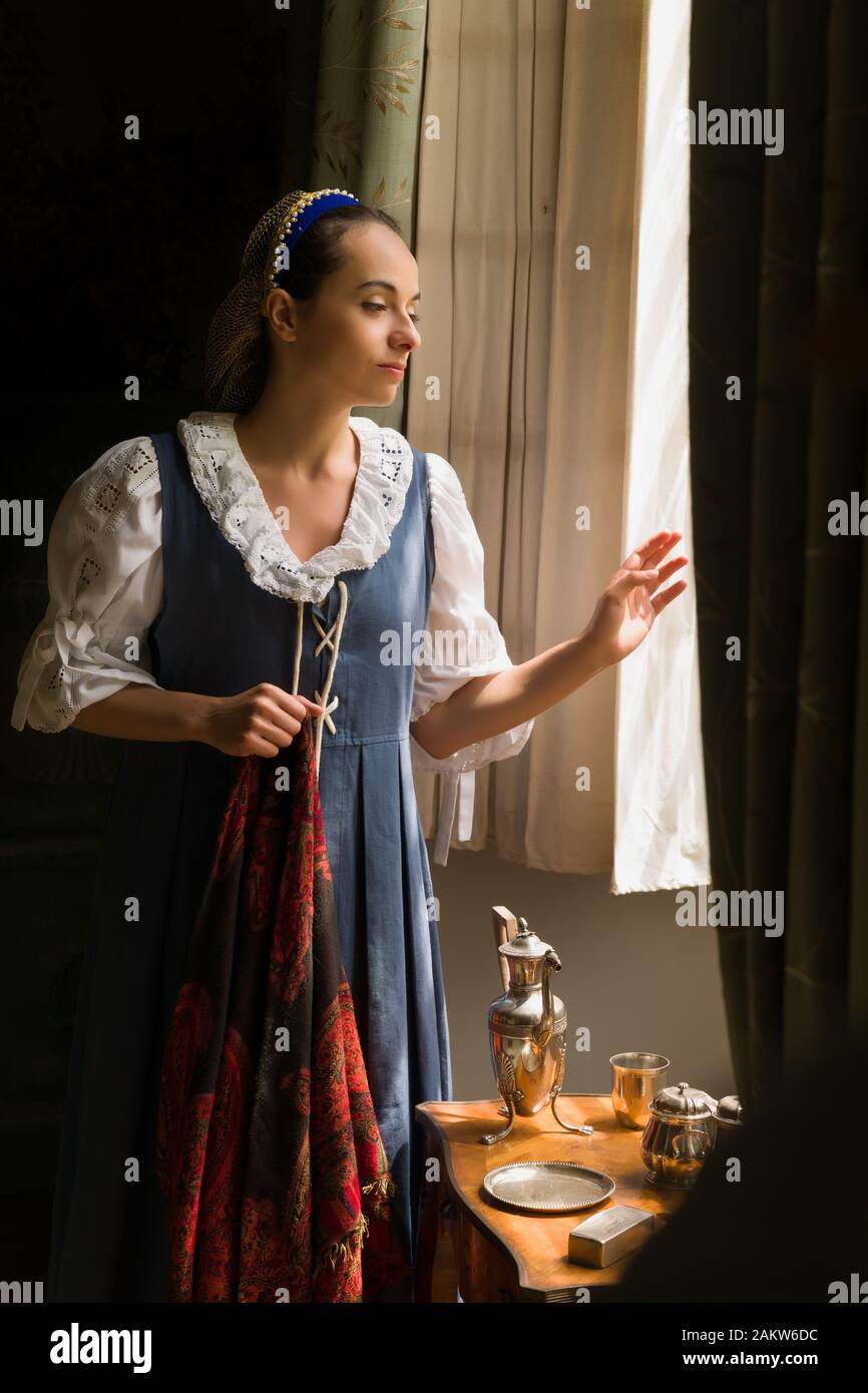 Jolie jeune femme en costume de la Renaissance à la fenêtre au moyen d ...