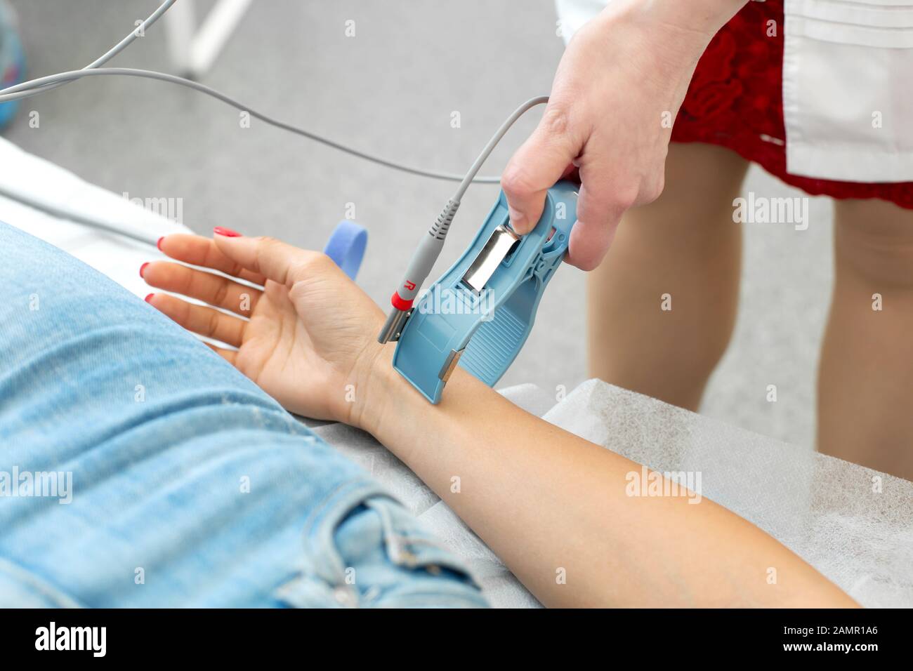 Le médecin attache les électrodes de l'ECG des pointes pour le poignet ...
