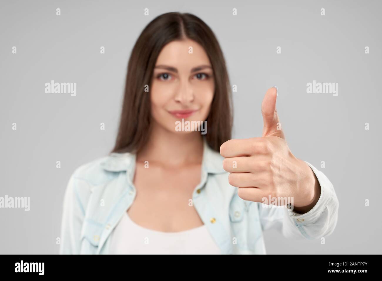 La mise au point sélective du pouce montré par une jeune femme de ...