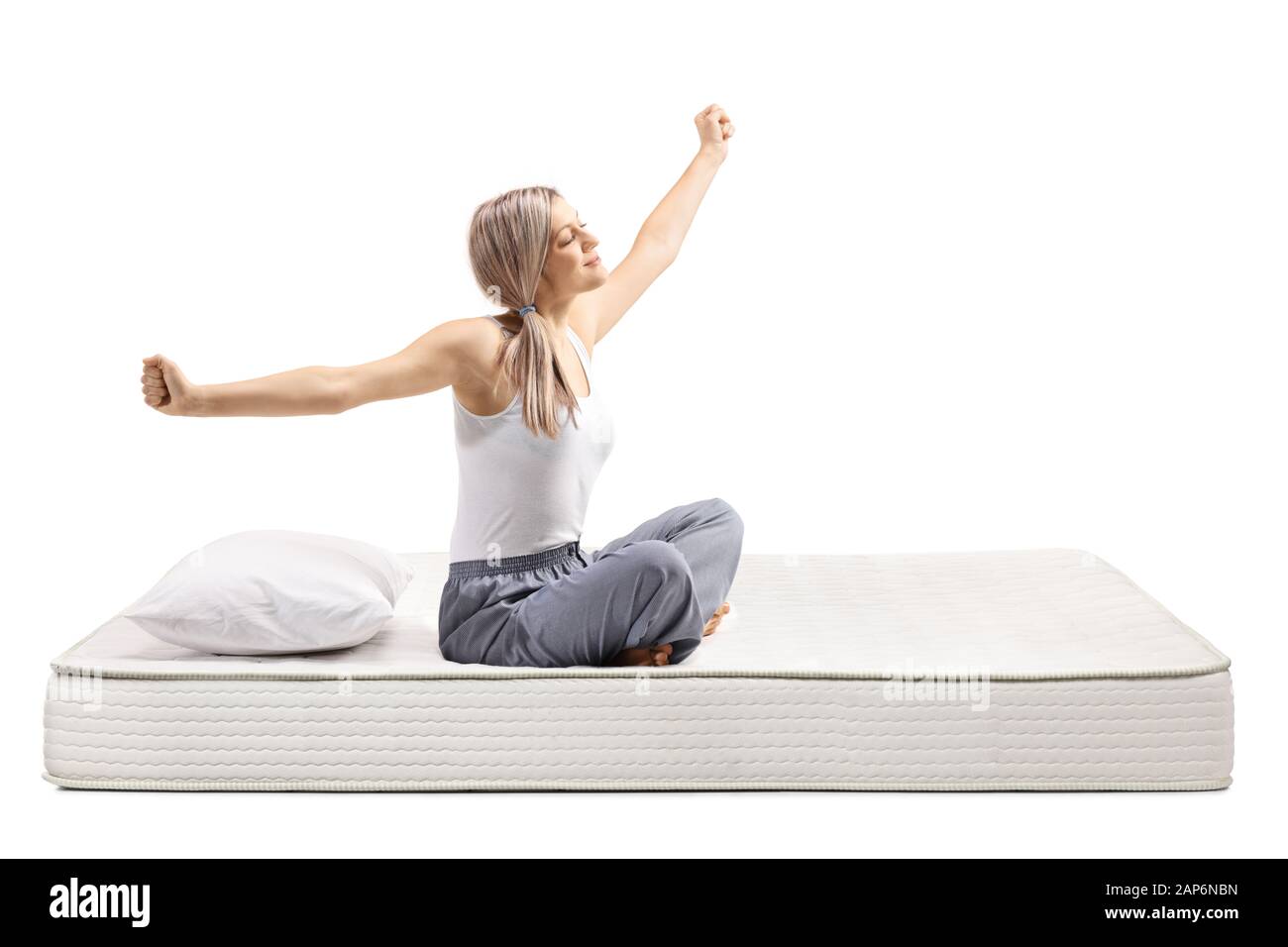 Jeune Femme Assise En Tailleur Sur Le Lit Banque De Photographies Et D