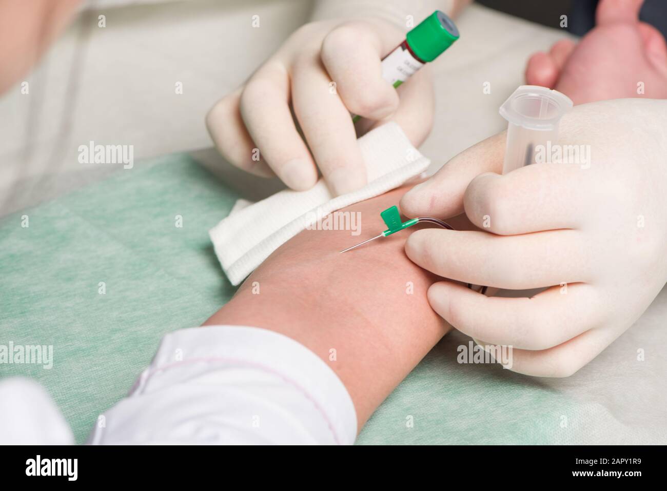 Les mains dans les gants médicaux en latex font une ponction veineuse ...