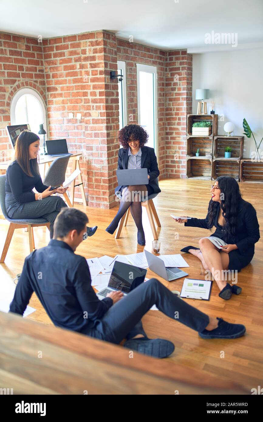 Groupe des travailleurs d'affaires souriant heureux et confiant. Assis sur le plancher détendue ...