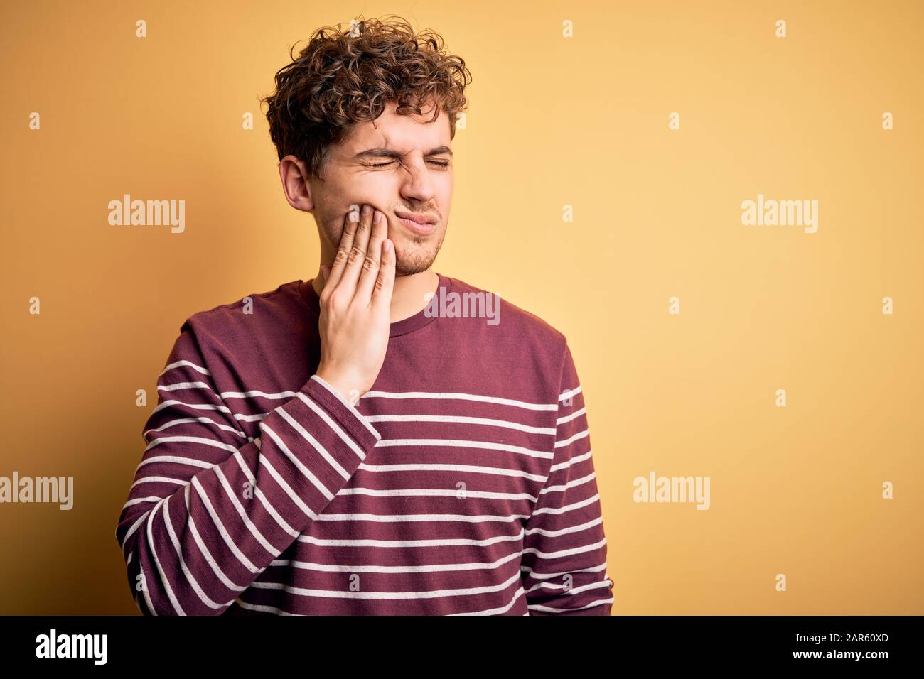 Jeune homme blond avec des cheveux cousues portant décontracté pull ...