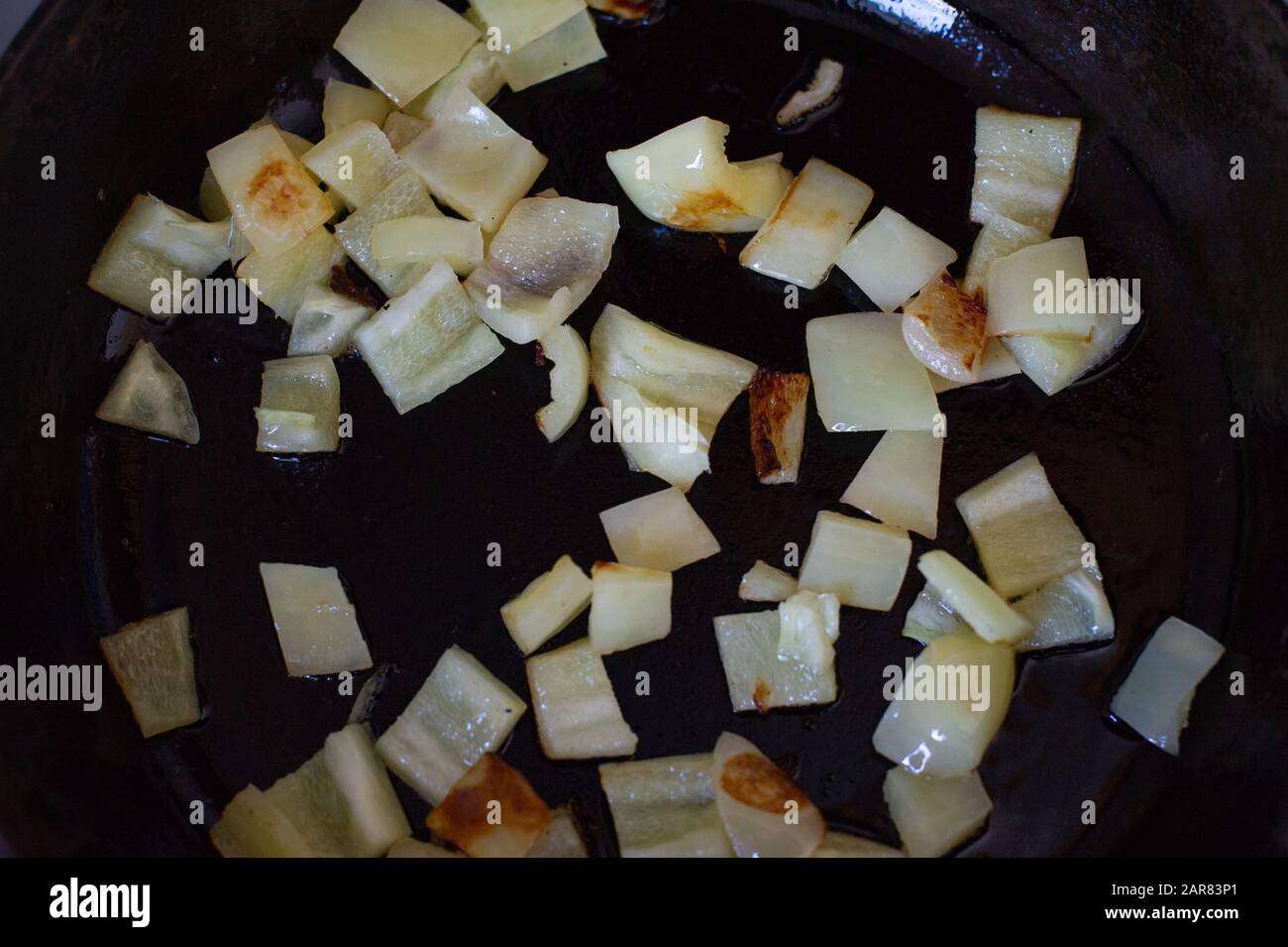 Légumes coupés en cubes frits sur la poêle à frire, dans la cuisine ...