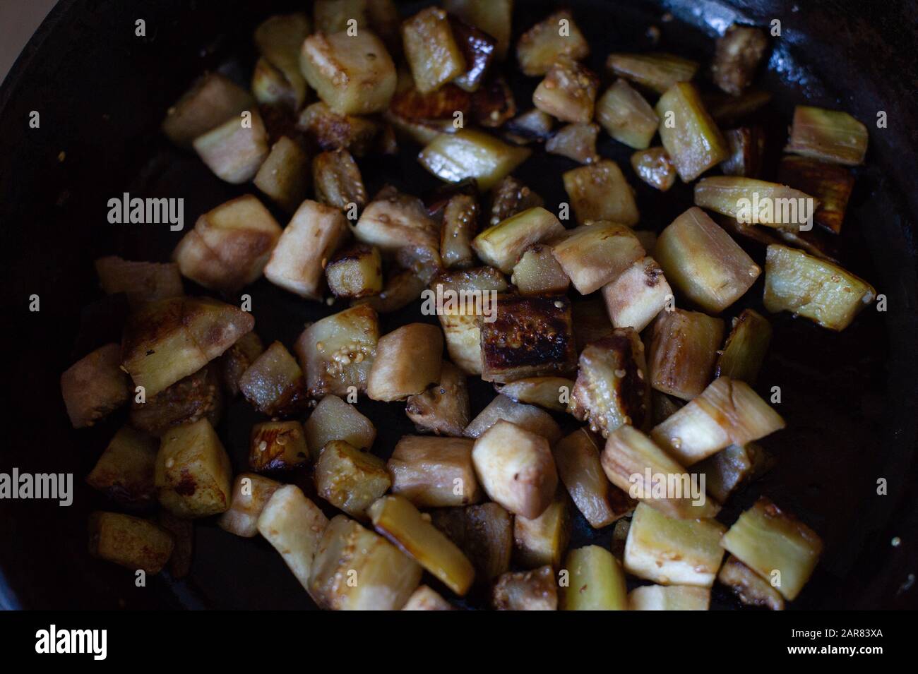 Légumes coupés en cubes frits sur la poêle à frire, dans la cuisine ...