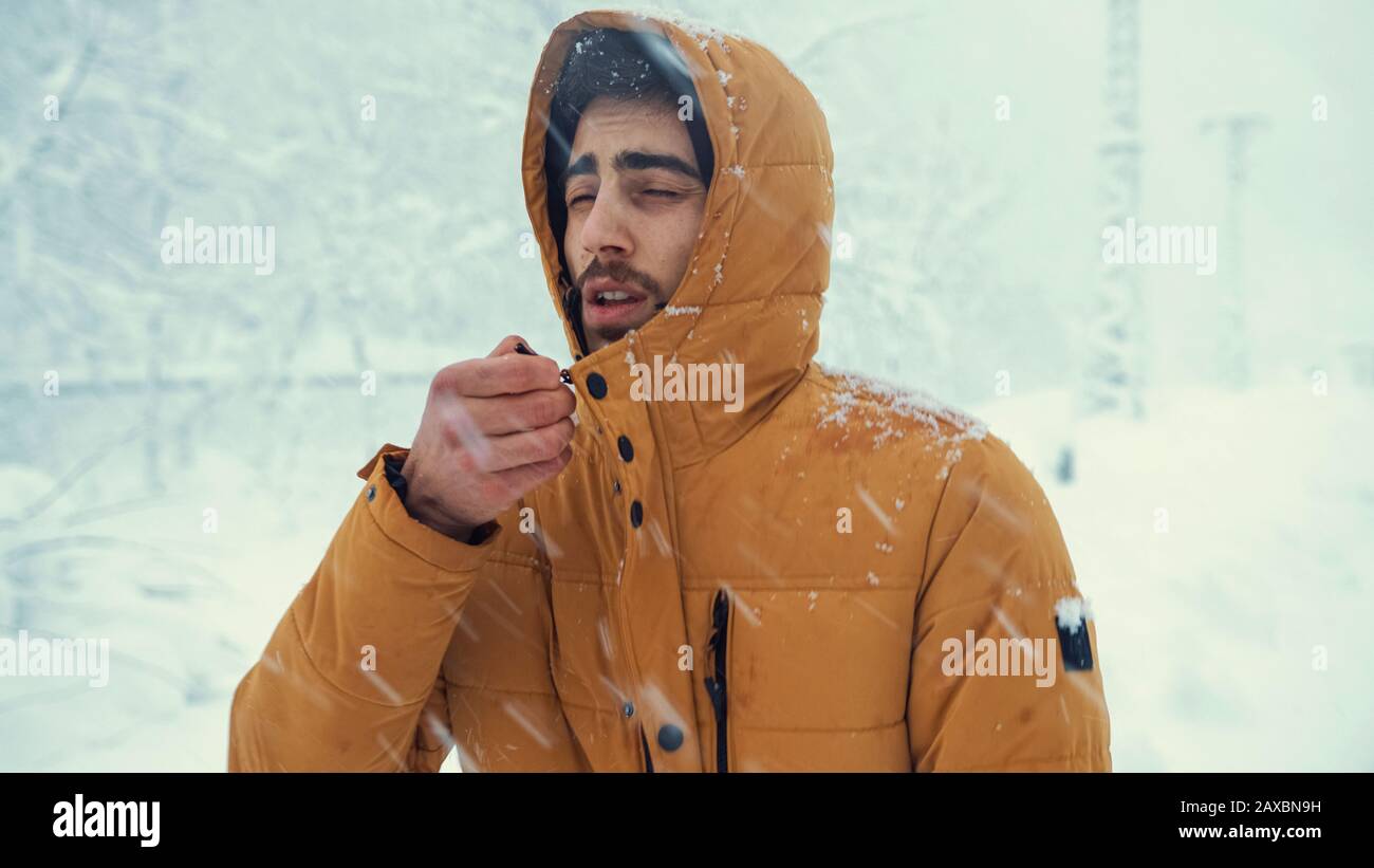 Portrait d'un homme froid portant un manteau qui a attrapé la neige ...