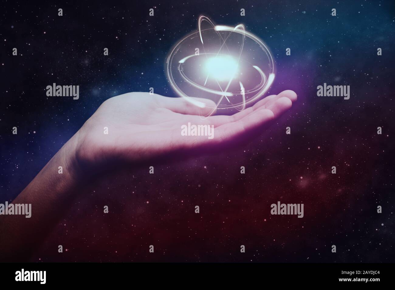 Main humaine tenant atome sur une paume. Poussière de nébuleuse dans un ...