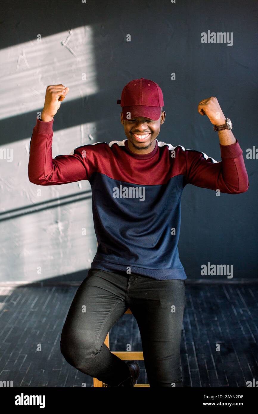 Portrait d'un jeune homme africain excité aux bras débordés et riant ...