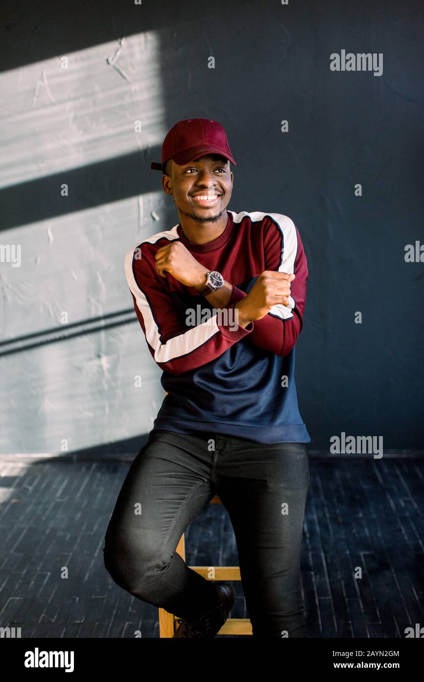 Portrait d'un jeune homme africain excité aux bras débordés et riant ...