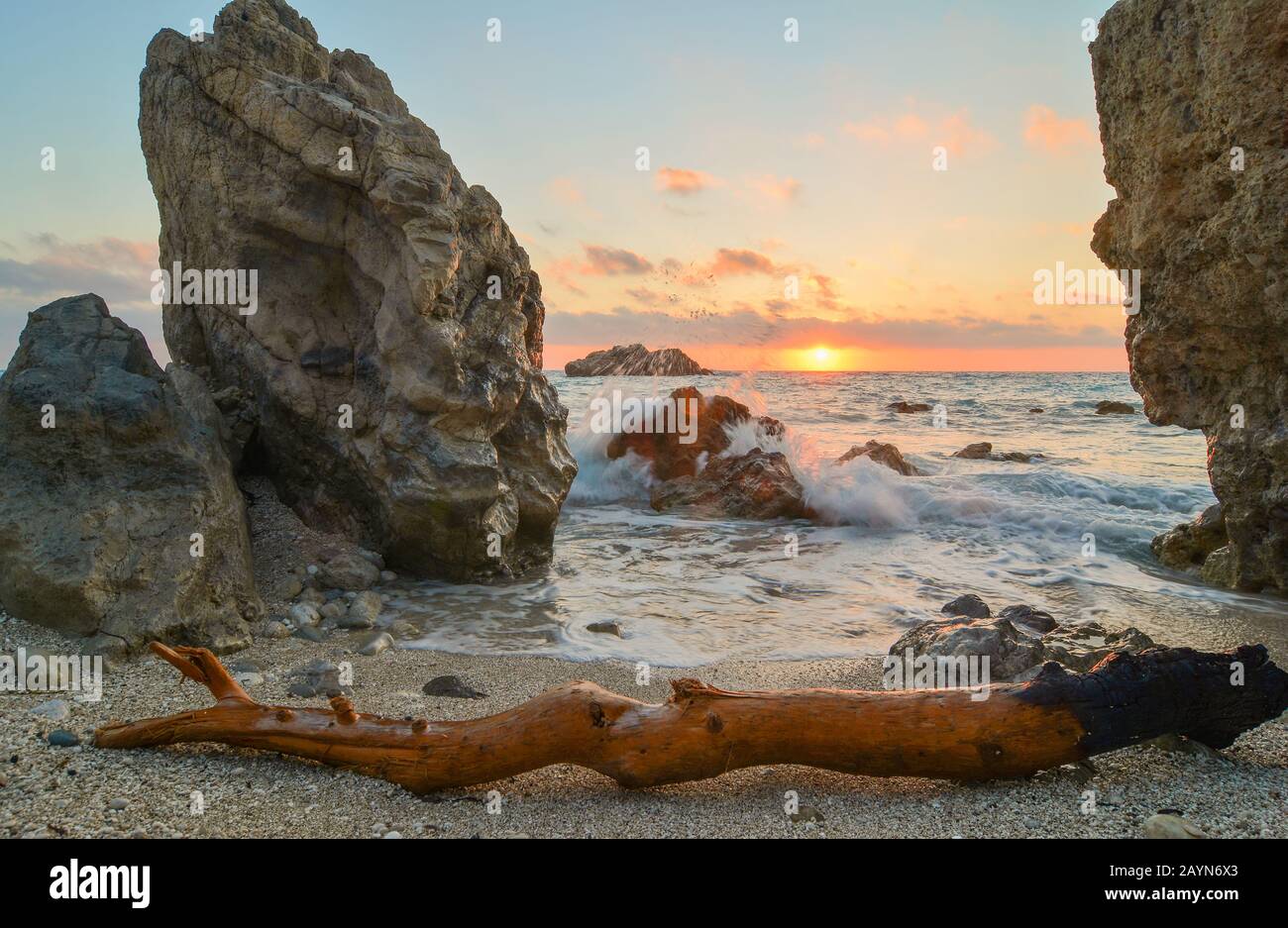 Coucher de soleil parmi les grandes roches, vagues laiteuses et grand ...