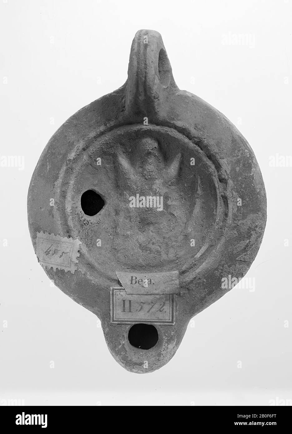 Une lampe marron avec un corps rond sur une base ronde. Le miroir rond ...