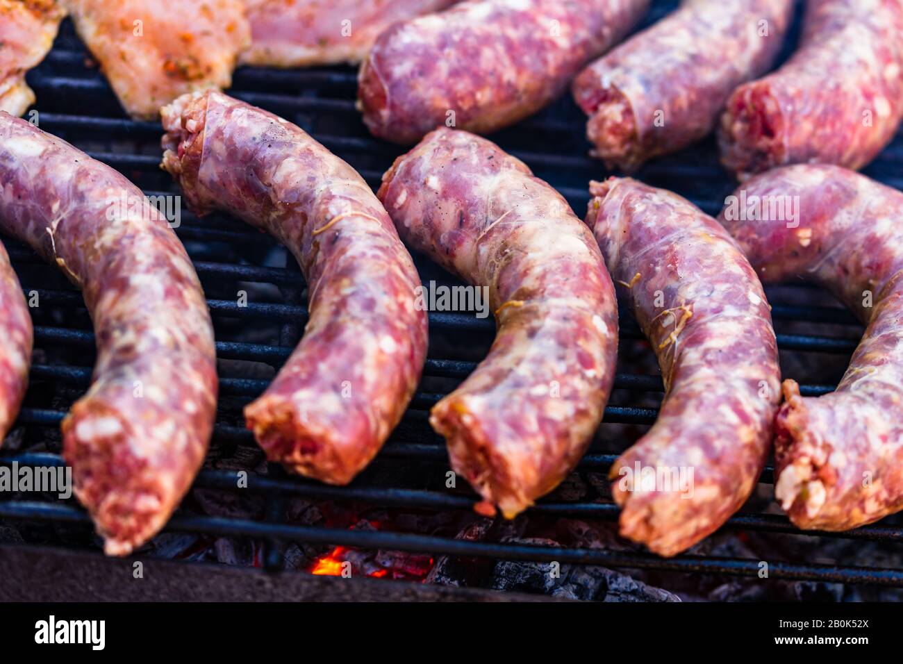 Faire cuire de la viande sur un gril. Saucisses et viande de porc ...