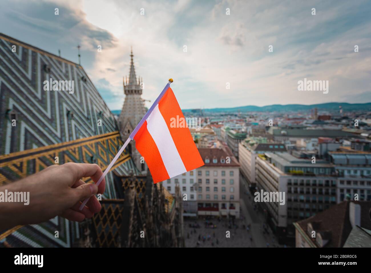 L'homme tient le drapeau autrichien à portée de main contre l'arrière ...