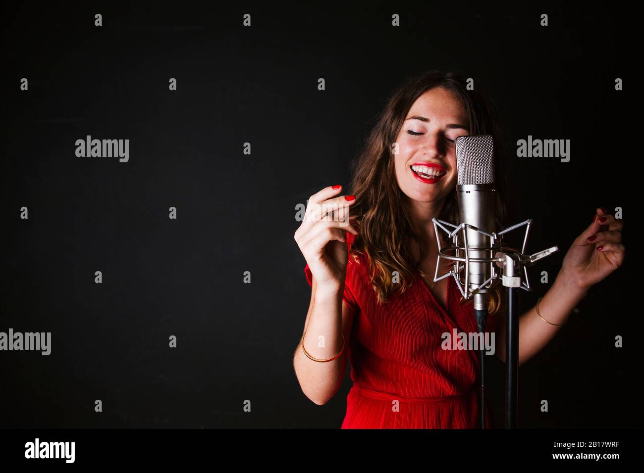 Portrait de la chanteuse féminine avec microphone, portant une robe ...