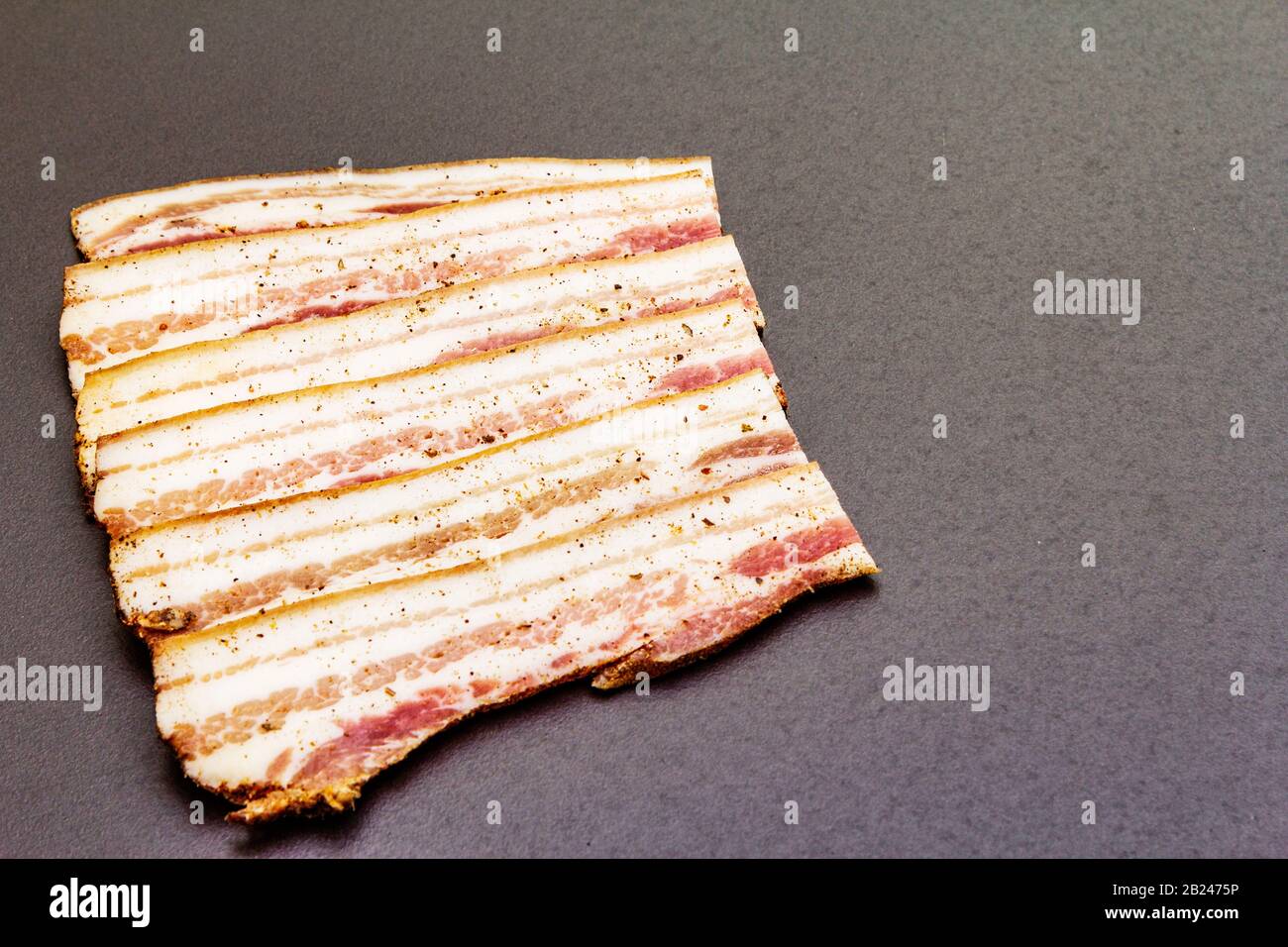 Tranches de bacon salé aux épices. Ingrédient brut traditionnel pour la ...