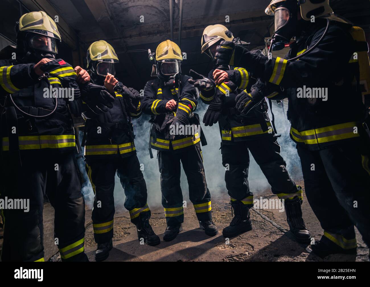 Équipe de pompiers du service incendie portant des masques à gaz et des ...