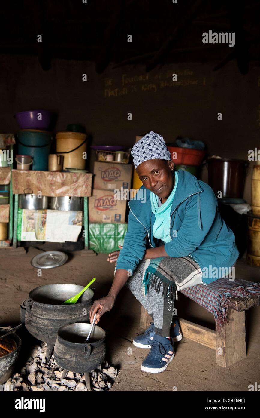 Femme cuisine à l'intérieur de sa hutte, village de Basotho, Sani Top ...