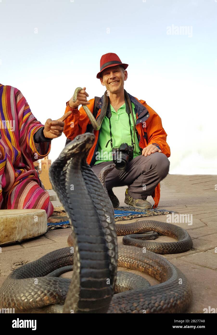 Un touriste heureux prenant des photos avec des serpents. Choses à ...