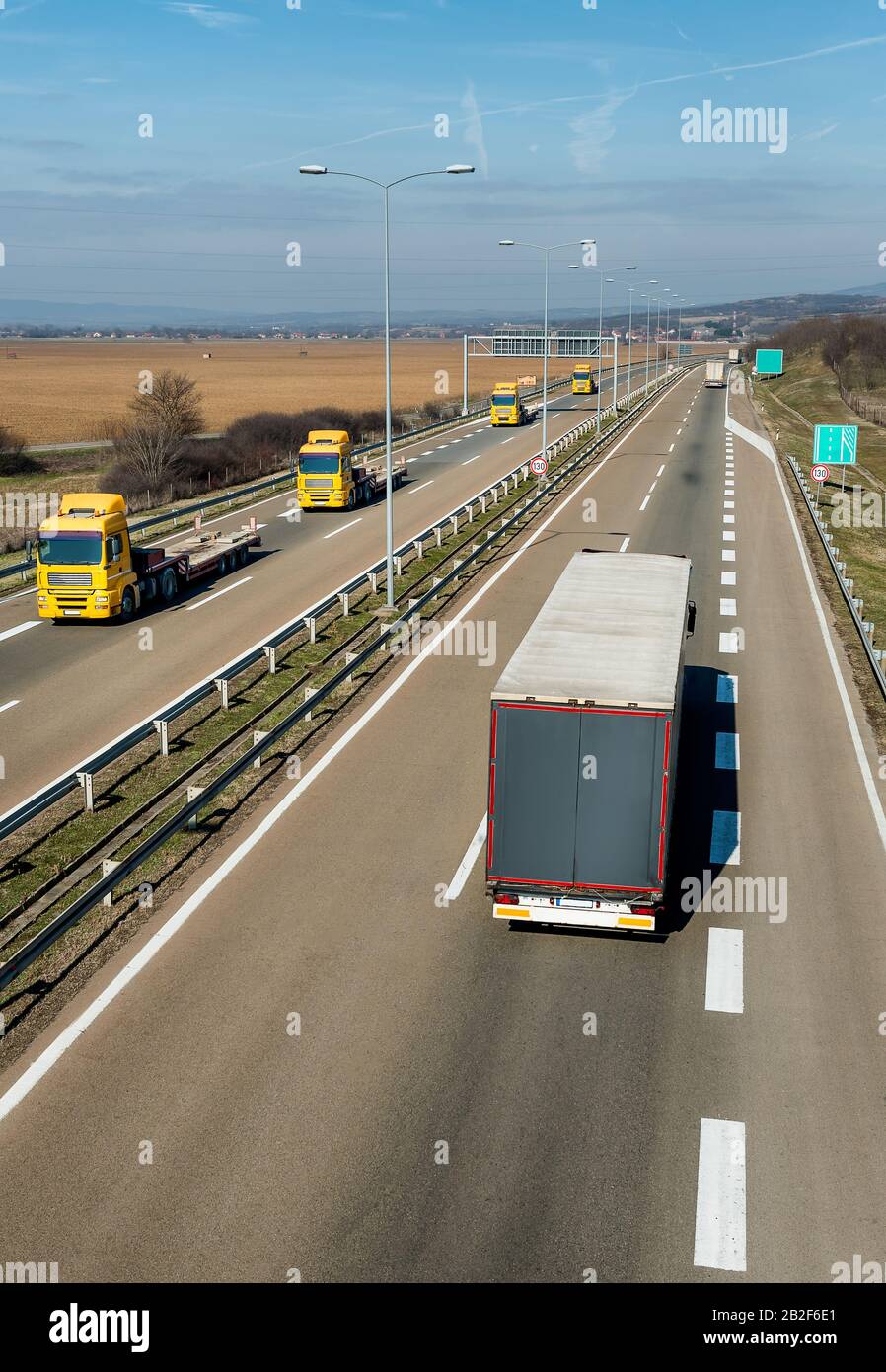 Convoi de camions de transport passant sur une autoroute par une ...