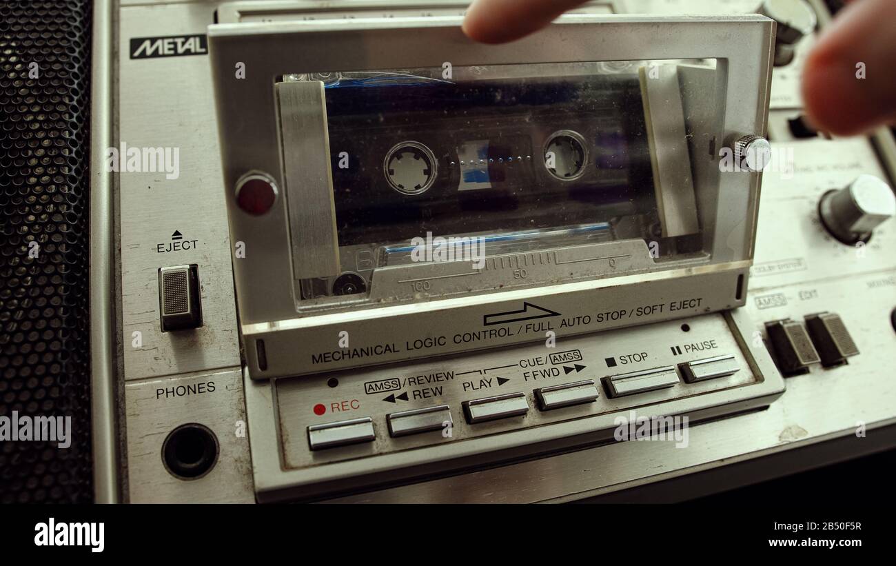 L'ancien lecteur de cassettes insère une cassette dans la boîte à ...