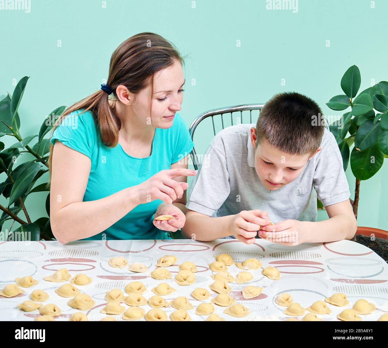Maman enseigne le fils à sculpter des boulettes avec du fromage cottage ...