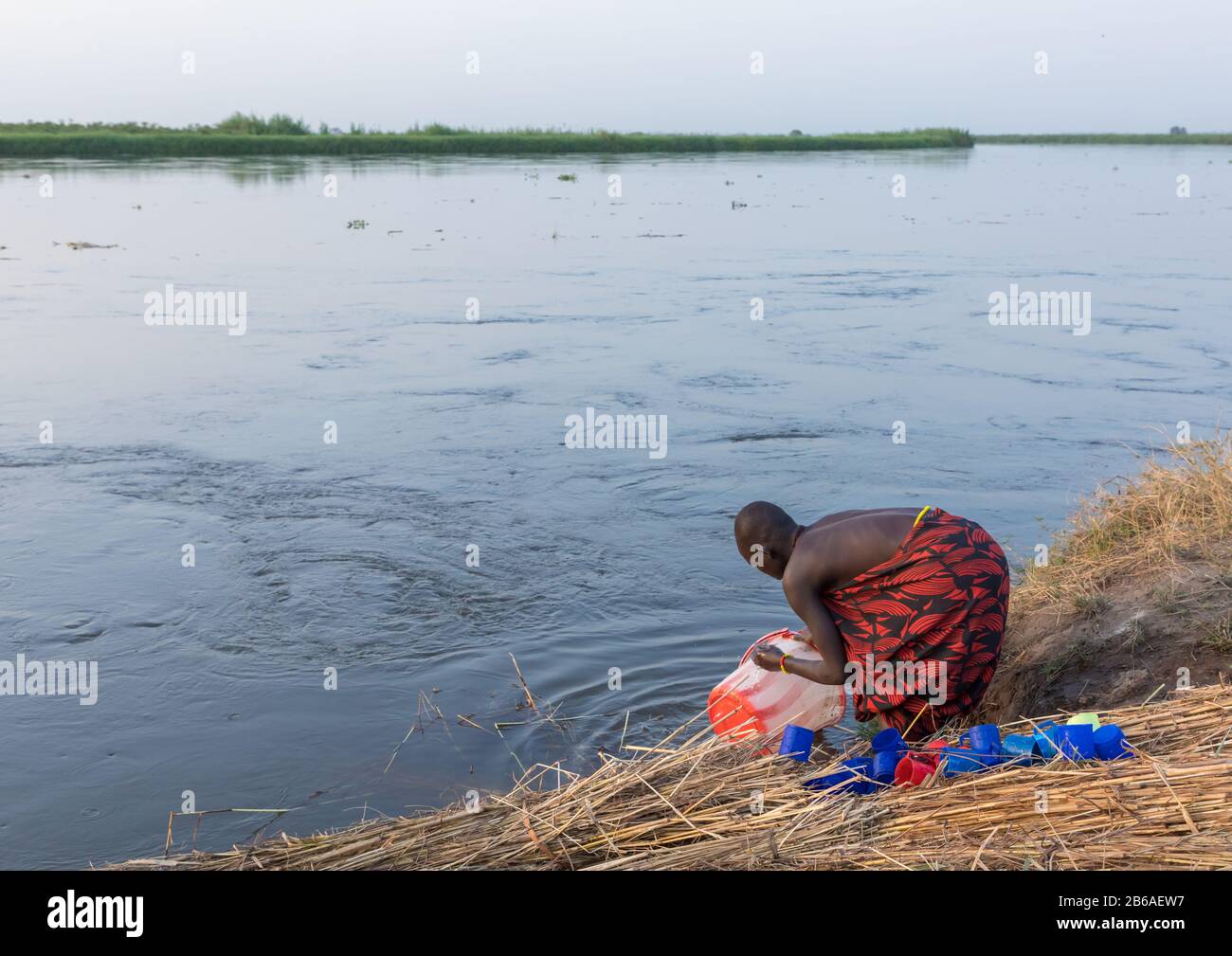 Les femmes de la tribu Mundari se lavent des seaux dans le Nil, l ...