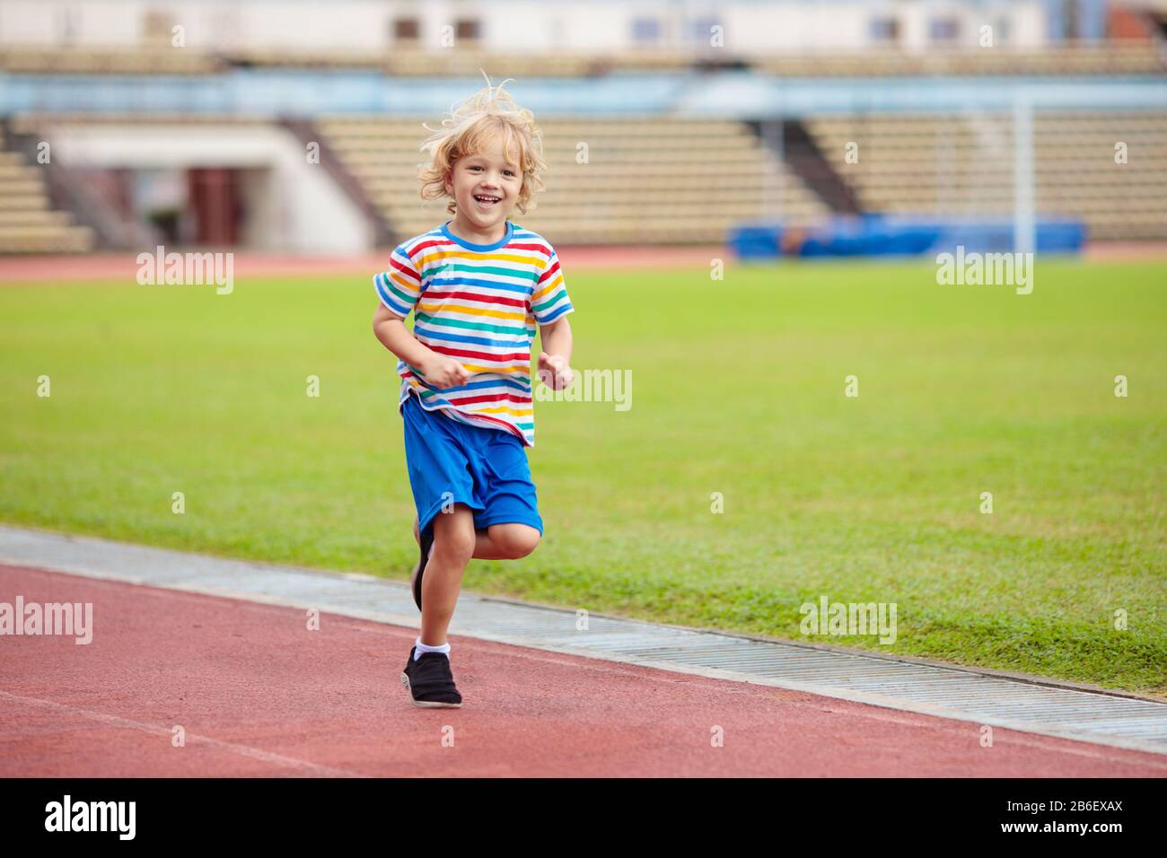Enfant en train de courir dans le stade. Les enfants courent sur une ...