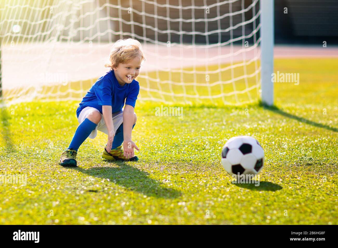 Les enfants jouent au football sur le terrain du stade extérieur. Les ...