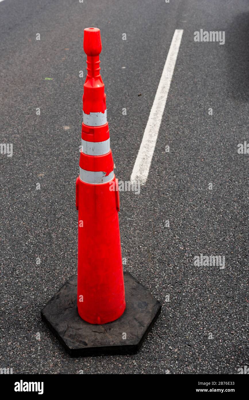 Grand cône de circulation orange sur route avec une ligne de guidage ...