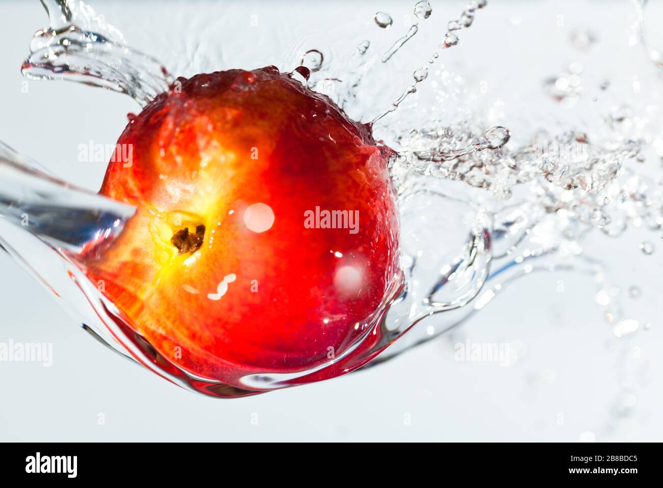 Gros plan photo de la pomme rouge dans l'eau sur fond blanc, eaux ...