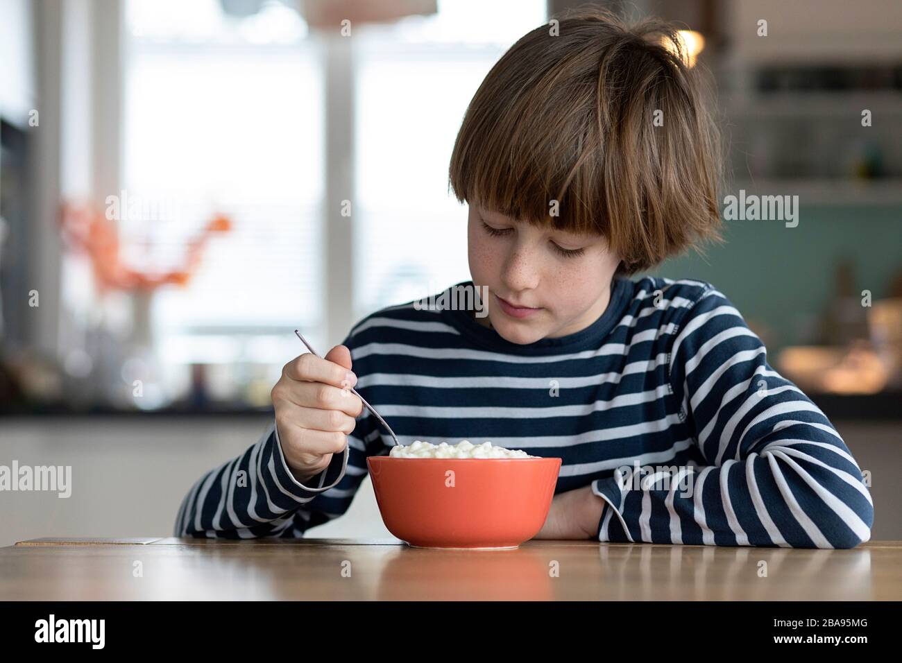 Enfant mangeant du riz au lait Banque de photographies et d’images à ...