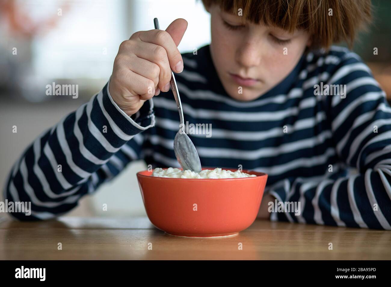Enfant mangeant du riz au lait Banque de photographies et d’images à ...