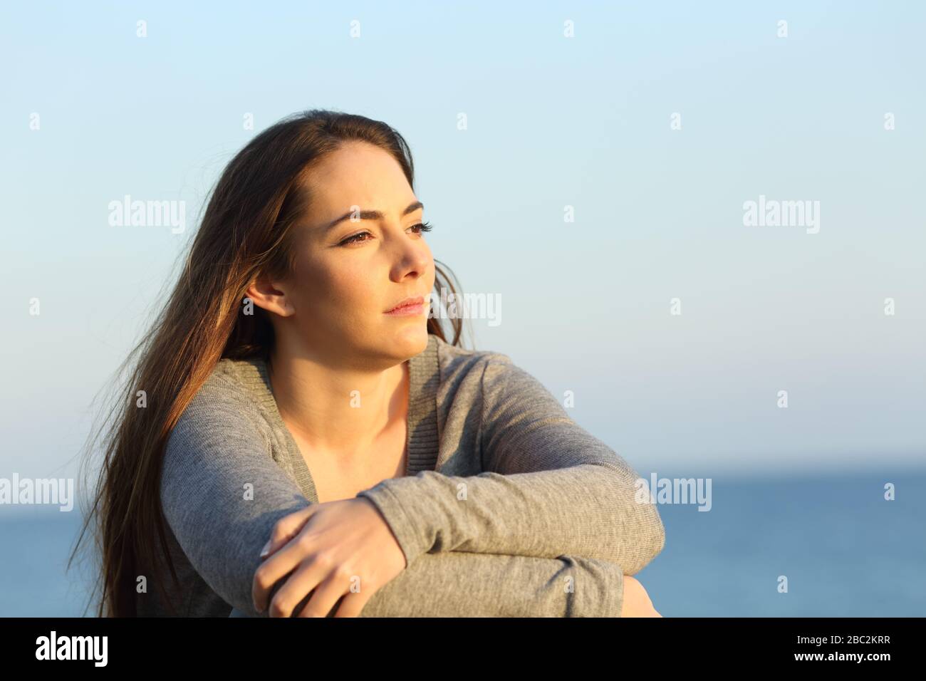 Sad Looking Girl Sitting On The Beach Banque De Photographies Et D
