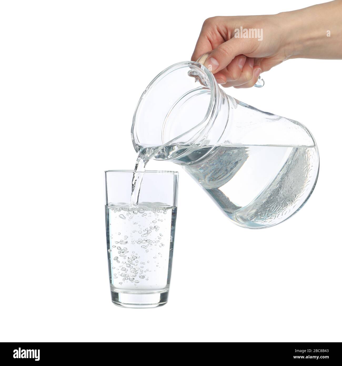 Verser de l'eau douce purifiée dans la verseuse en verre, isolée sur ...