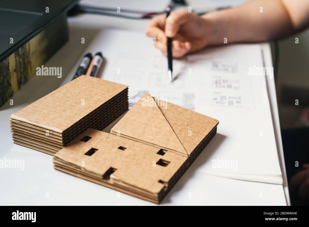 Bureau d'architecte avec modèle architectural en carton et croquis de ...