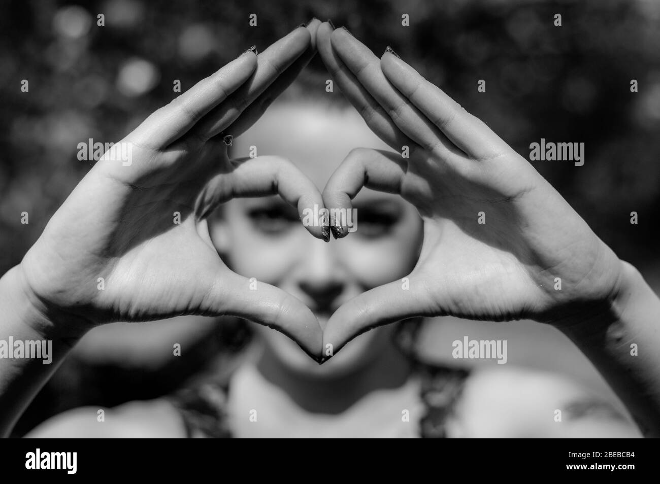 Signe de mains en forme de coeur. Jeune femme faisant un coeur avec les ...