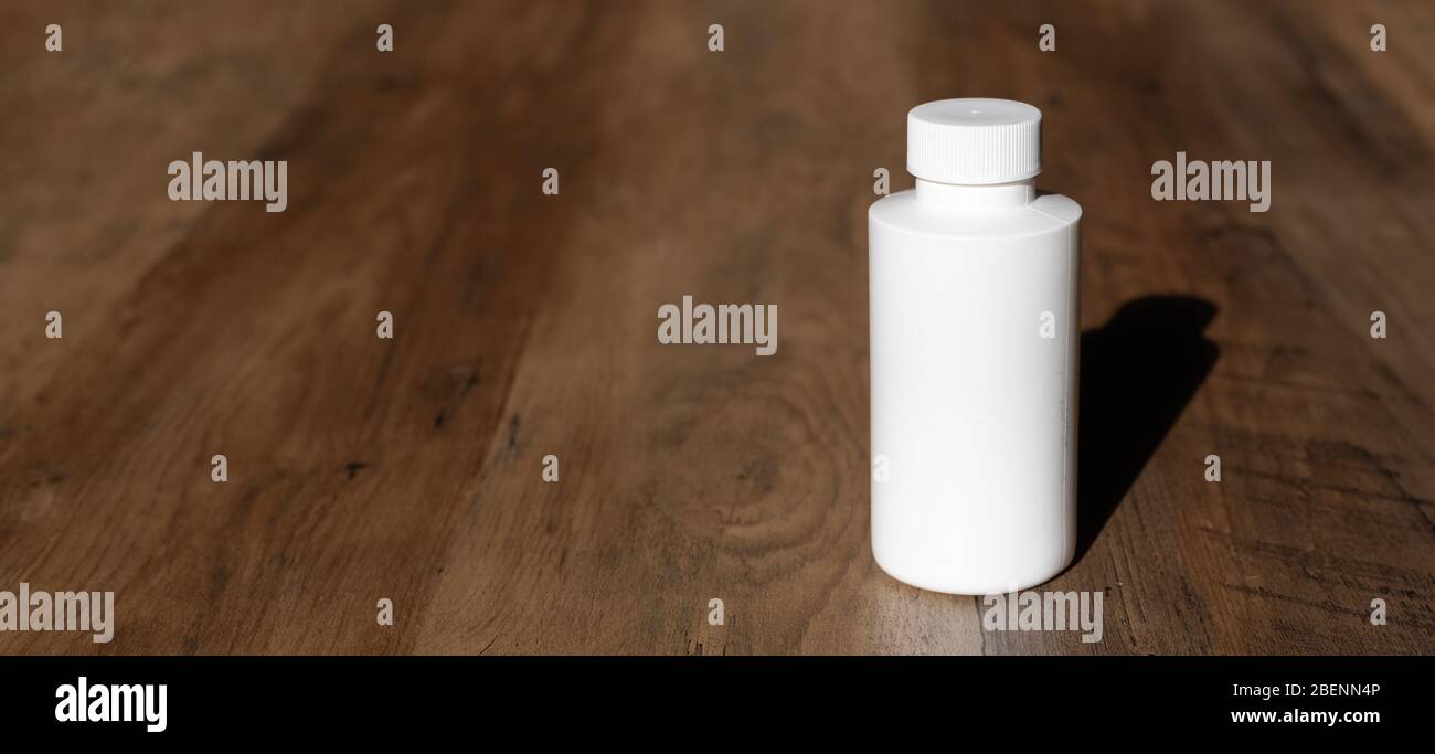 Bouteille blanche sur fond en bois et ombre. Flacon de solvant chimique ...