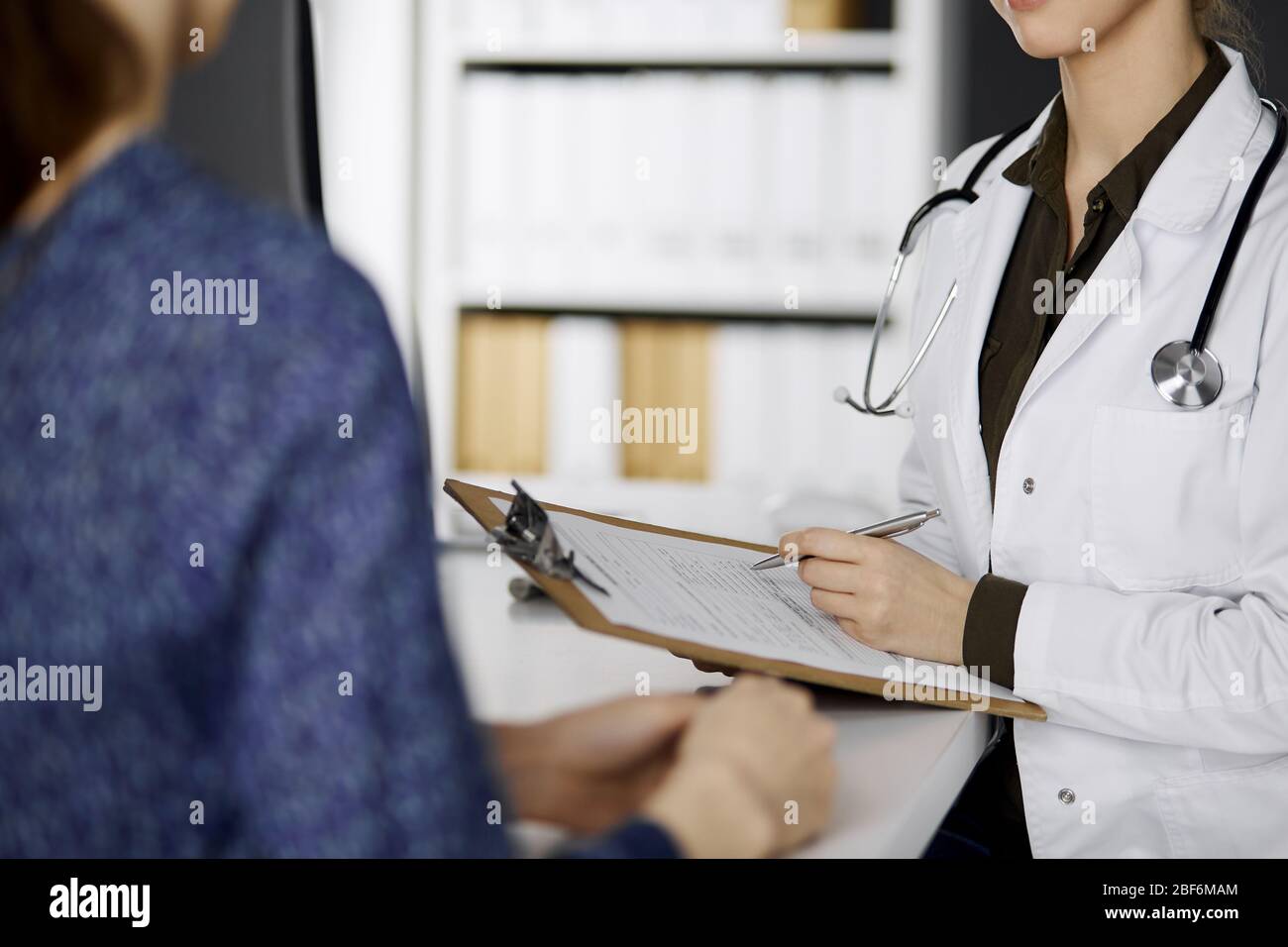 Médecin et patient discutant de l'examen de santé en cours lorsqu'ils ...