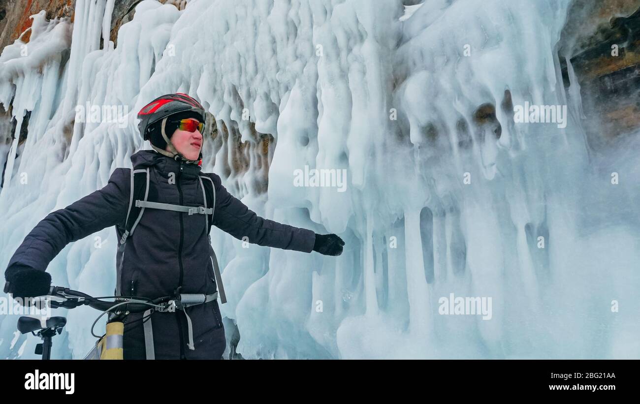 L'homme est à vélo près de la grotte de glace. Roche avec des grottes ...