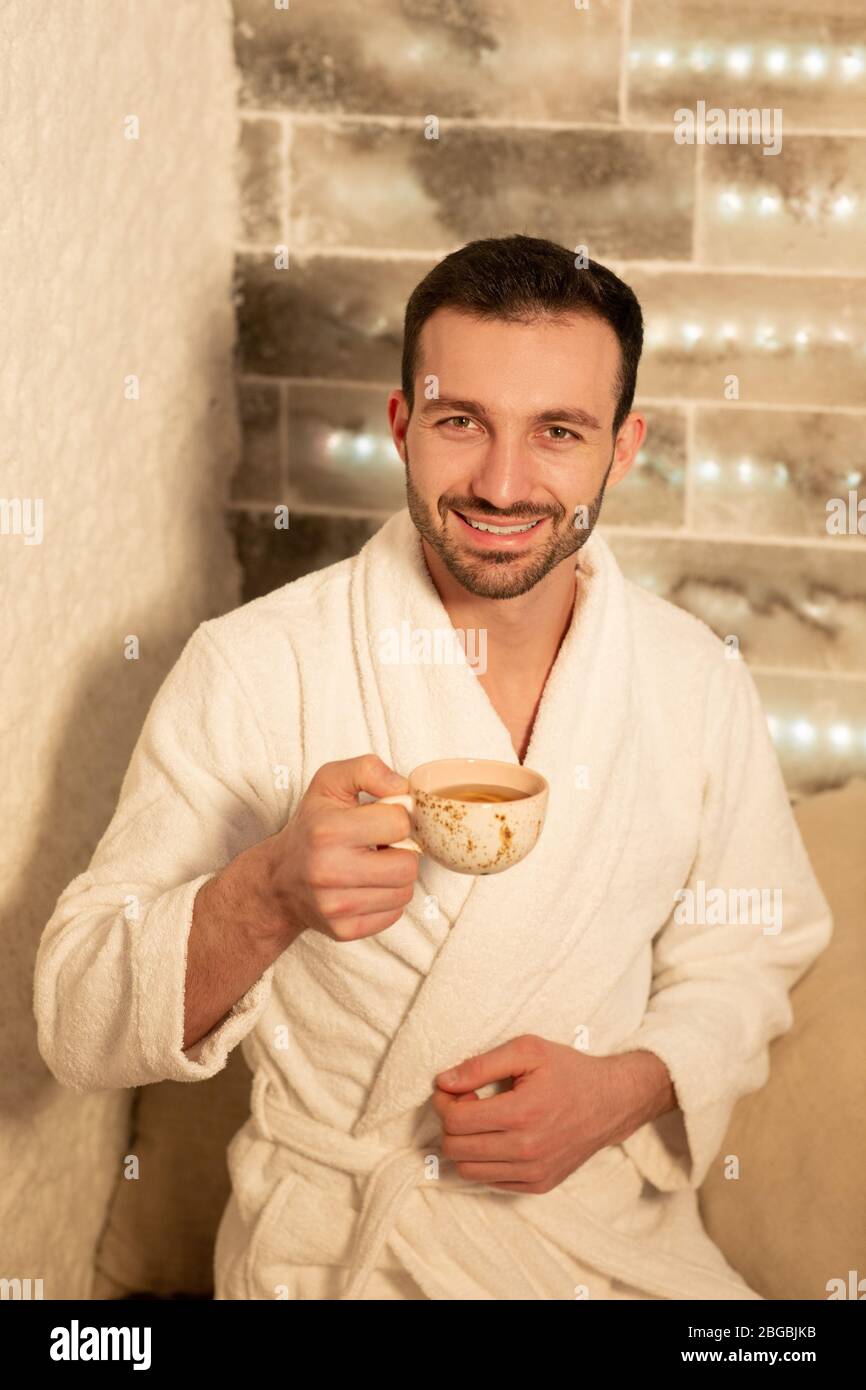 Un homme qui boit du thé bien-être et inhalant de l'air sain et salé ...