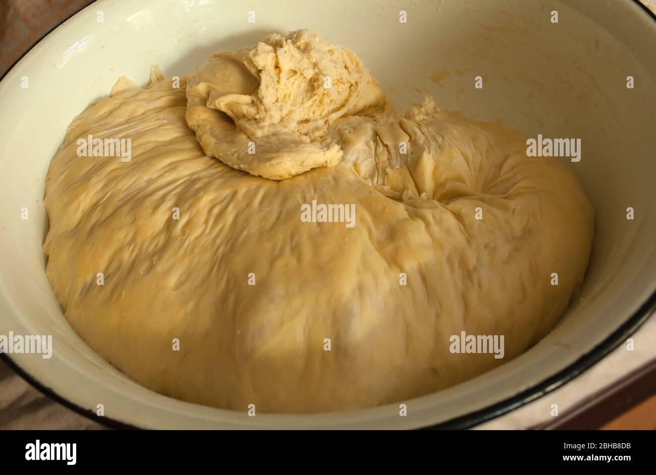 Pâte à levure sur les patties, représentée pâte dans un grand bol, la ...