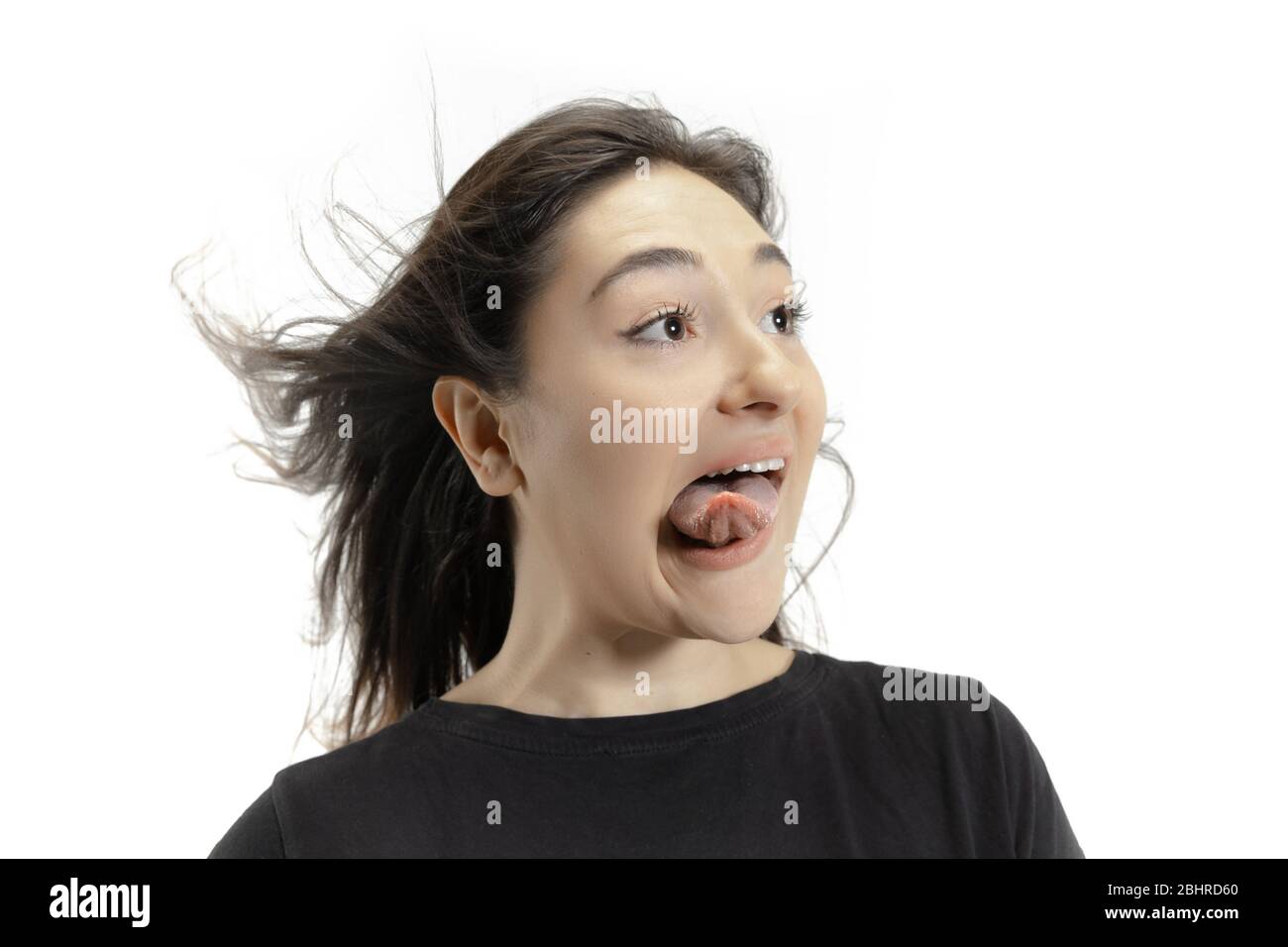 Une jeune fille souriante ouvrant la bouche et montrant la longue ...