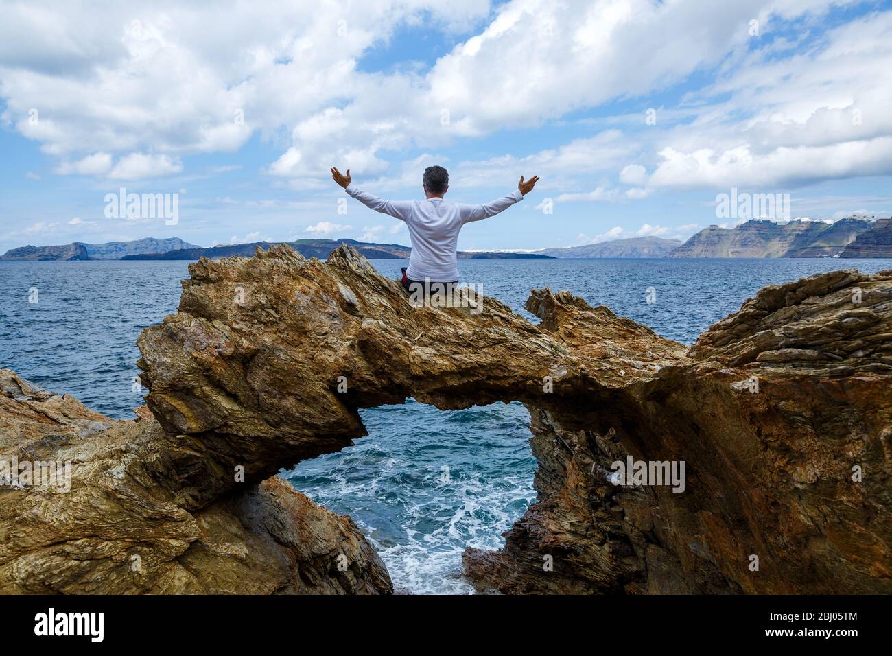 L'homme admire la mer sur un beau rocher en pierre avec une arche ...
