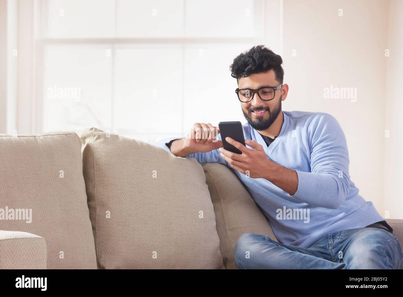 Homme assi dans son canape Banque de photographies et d’images à haute ...