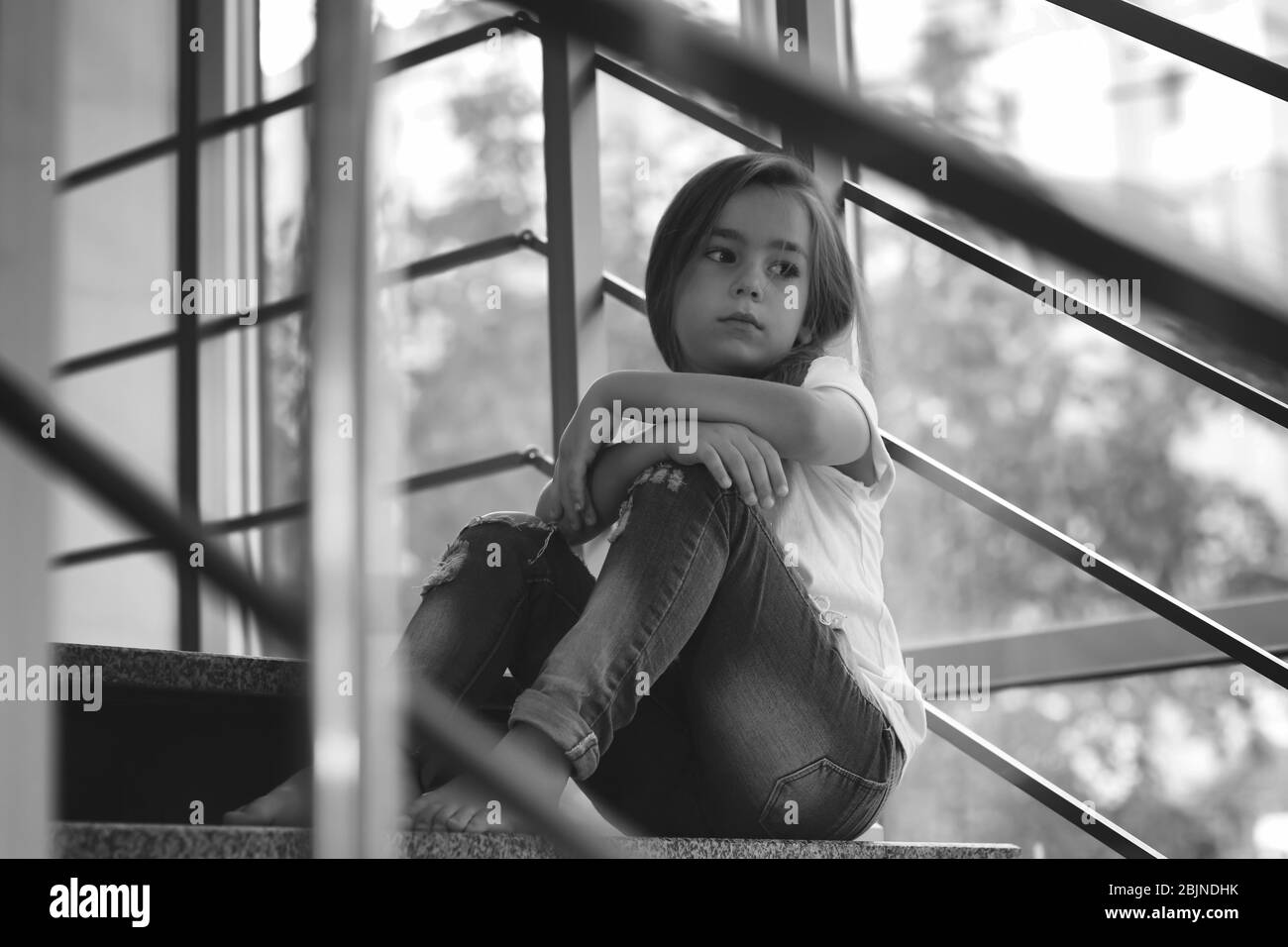 Petite fille assise escalier Banque d'images noir et blanc - Alamy
