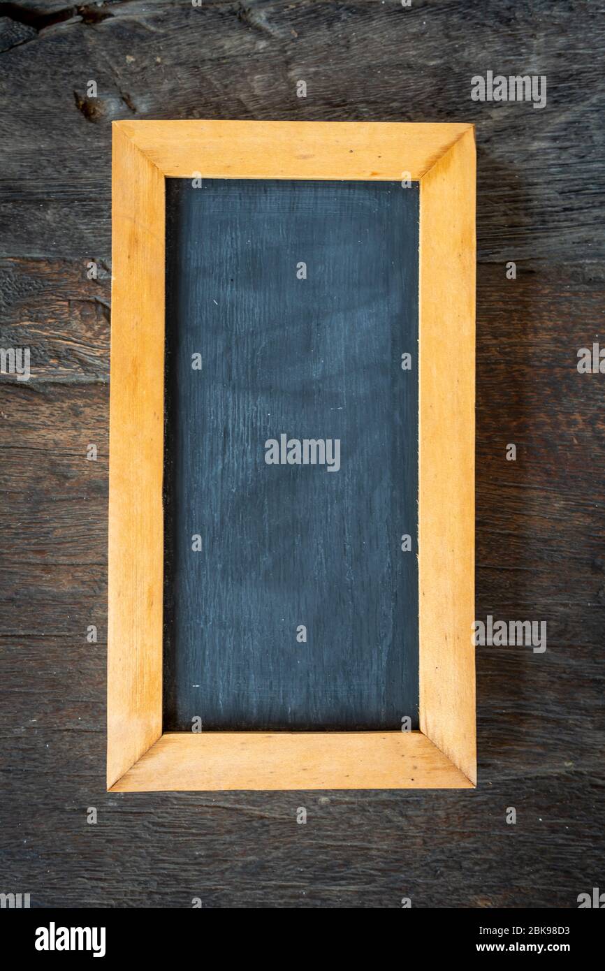 Vider le tableau de craie vertical sur fond en bois. Bard noir vierge ...
