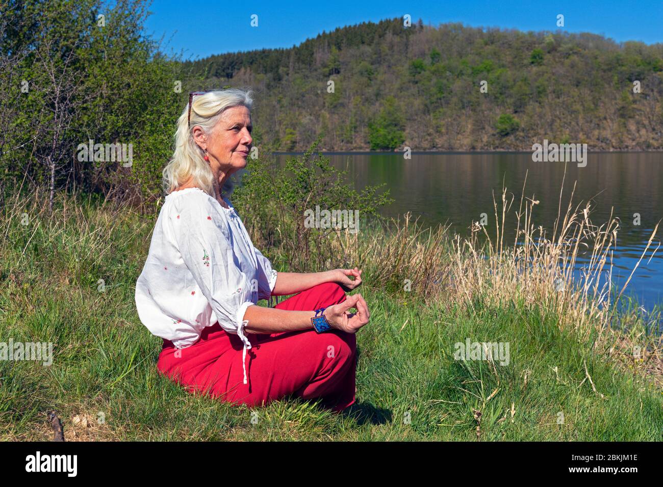Woman meditating lake Banque de photographies et d’images à haute ...