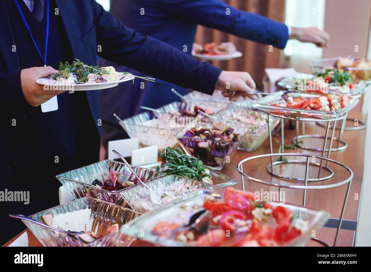 Les mains des personnes prenant la nourriture avec couvert de verts et ...