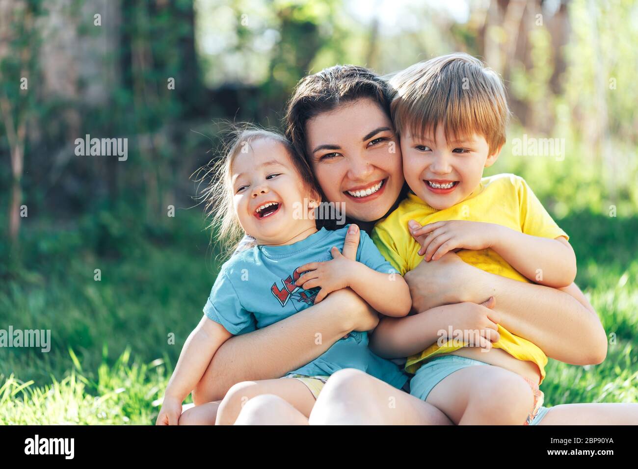 Jeune Belle Mère Avec Son Fils Et Sa Fille Sassoient Sur Une Pelouse