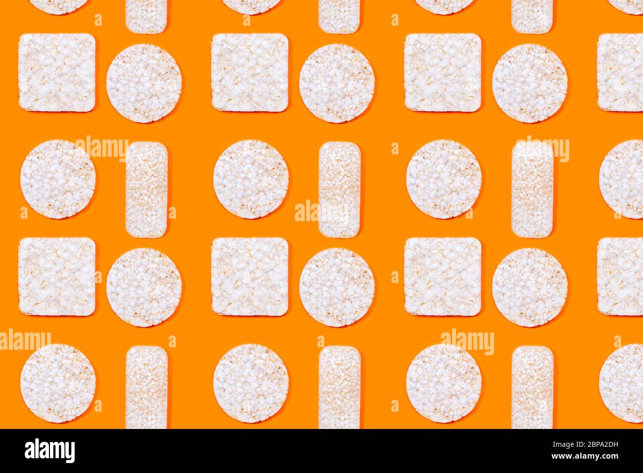 Motif composé de craquelins de riz ou de gâteaux de riz sur fond orange ...